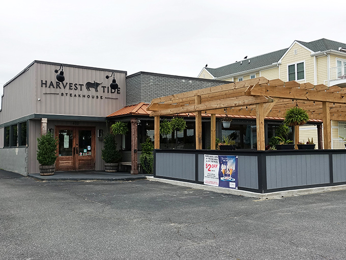The coastal charm of Harvest Tide's exterior belies the culinary magic happening inside. Gray siding, brick accents, and wooden beams create an inviting first impression.