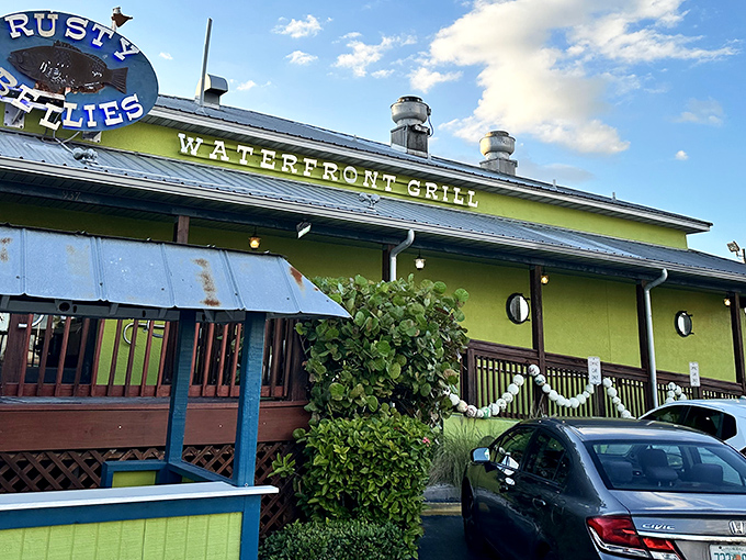 The lime-green exterior of Rusty Bellies stands out like a tropical beacon, promising seafood treasures within its cheerful waterfront walls.