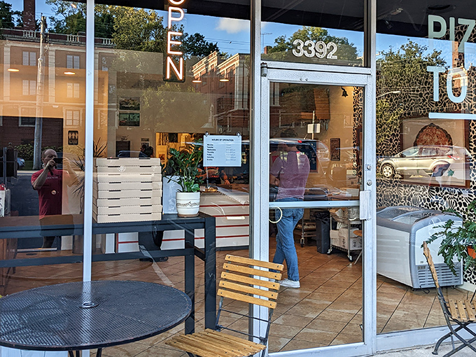 The wooden sign beckons like a secret handshake. Saint Francis Apizza's unassuming storefront hides pizza greatness behind glass doors on Erie Avenue.