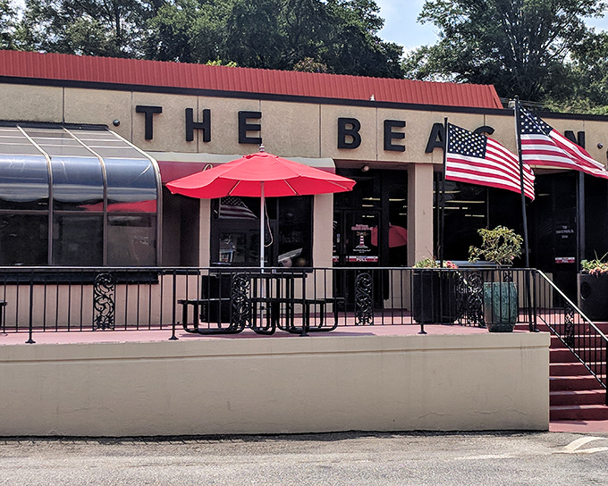 The iconic cream-colored exterior of The Beacon, with its bold signage and American flags, stands as Spartanburg's culinary lighthouse guiding hungry travelers home.