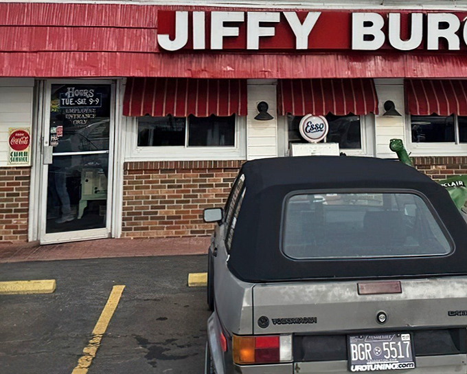 The green Sinclair dinosaur stands guard outside Jiffy Burger like a prehistoric bouncer who's really into comfort food. Red awnings and vintage gas pumps complete this time-travel tableau.