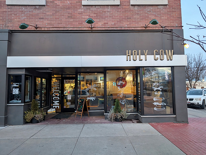 Gold lettering against a sleek gray facade announces your arrival at burger paradise. The crowned cow silhouette promises a royal feast awaits.