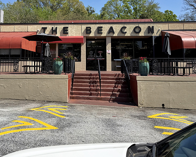 The iconic cream-colored exterior of The Beacon, with its bold signage and American flags, stands as Spartanburg's culinary lighthouse guiding hungry travelers home.