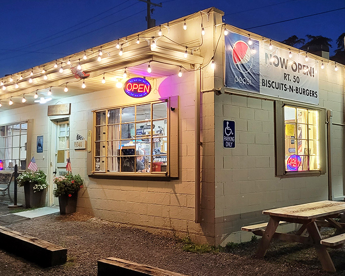 The humble exterior of Rt.50 Biscuits & Burgers glows with promise at dusk, string lights beckoning hungry travelers like a culinary lighthouse in Romney.