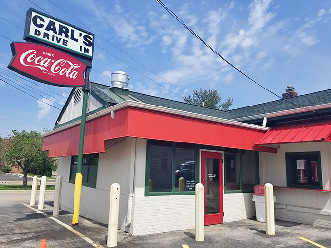 The classic red-awninged exterior of Carl's Drive-In stands as a Route 66 time capsule, beckoning hungry travelers with promises of nostalgia and root beer.