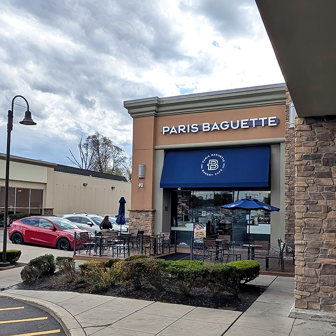 The Edison outpost of Paris Baguette beckons with its distinctive blue awnings and stone facade – like a modern French café that somehow landed in a New Jersey strip mall.
