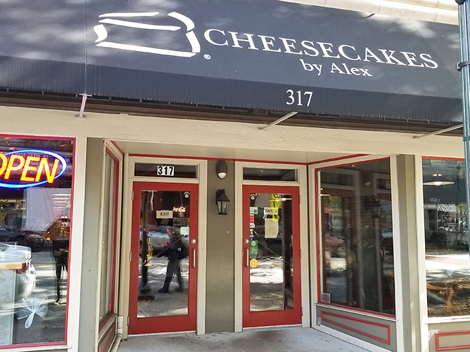 The navy blue awning of Cheesecakes by Alex beckons like a dessert lighthouse on Greensboro's Elm Street, promising sweet salvation for the sugar-deprived.