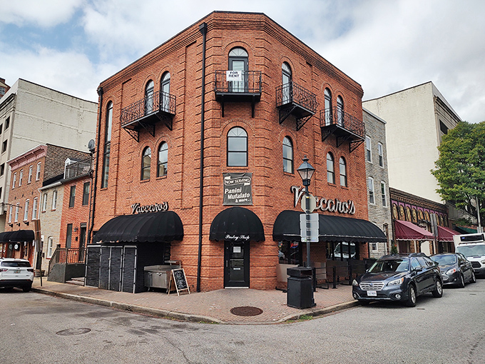 The corner brick building stands like a sentry guarding Little Italy's sweetest treasures, its black awnings a beacon for dessert pilgrims.