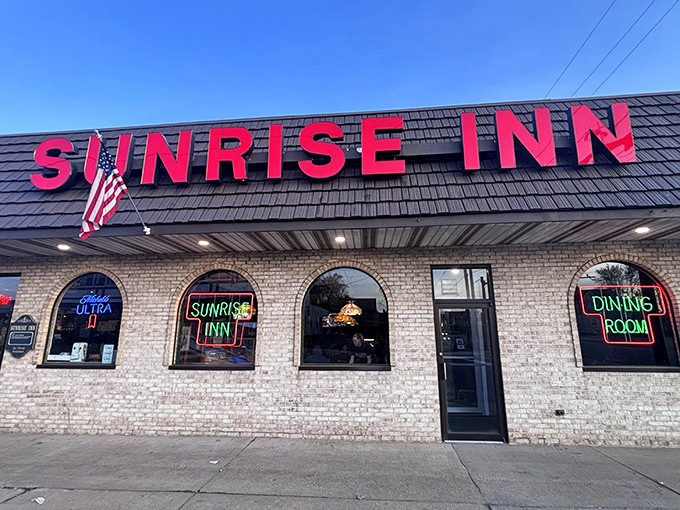 The unassuming exterior of Sunrise Inn hides culinary treasures within, like finding a Picasso at a yard sale. Those red letters promise pizza paradise.