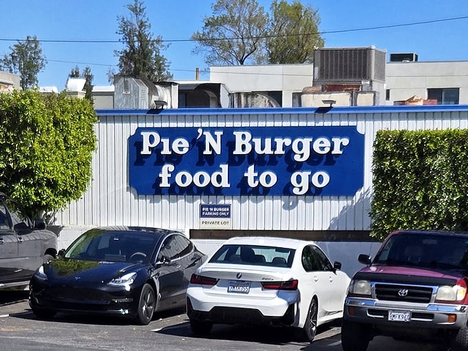 The iconic blue-trimmed storefront beckons like a time portal to simpler days when burgers were burgers and pies were the grand finale, not an afterthought.
