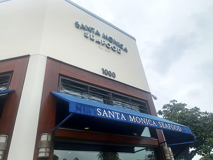 The iconic blue awning of Santa Monica Seafood beckons seafood lovers like a maritime lighthouse guiding hungry sailors to shore.