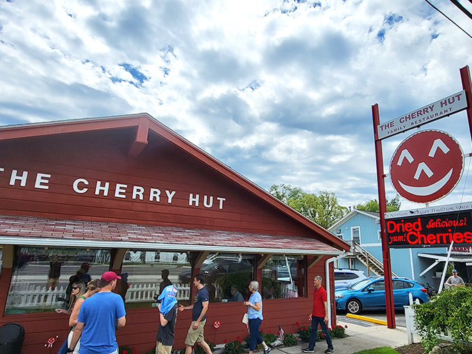 The Cherry Hut's cheerful red exterior isn't just a building&mdash;it's a promise of the ruby delights waiting inside. Complete with Cherry Jerry mascot standing guard!