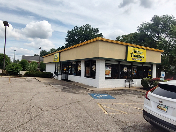 The iconic yellow and green sign stands like a lighthouse for fish and chips enthusiasts, beckoning hungry travelers to this rare surviving Arthur Treacher's outpost.