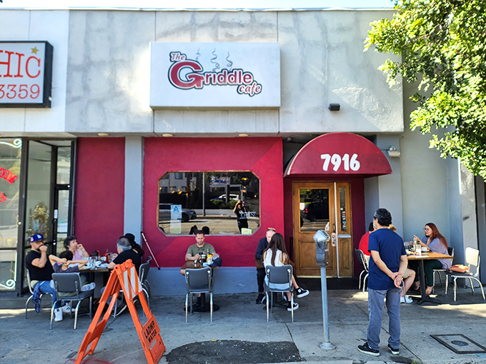 That crimson awning beckons like a breakfast lighthouse, promising pancake adventures that defy all reasonable portion expectations.