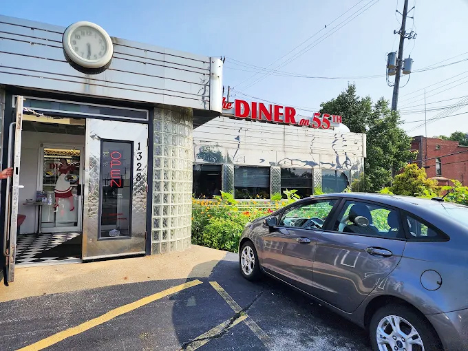 The gleaming stainless steel exterior of Diner on 55th stands like a time machine to the golden age of American dining. That vintage clock isn't just keeping time&mdash;it's preserving it.