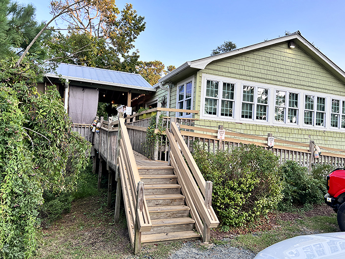 A coastal cottage that promises culinary magic. The wooden staircase leads to seafood heaven disguised as an unassuming green-shingled home.