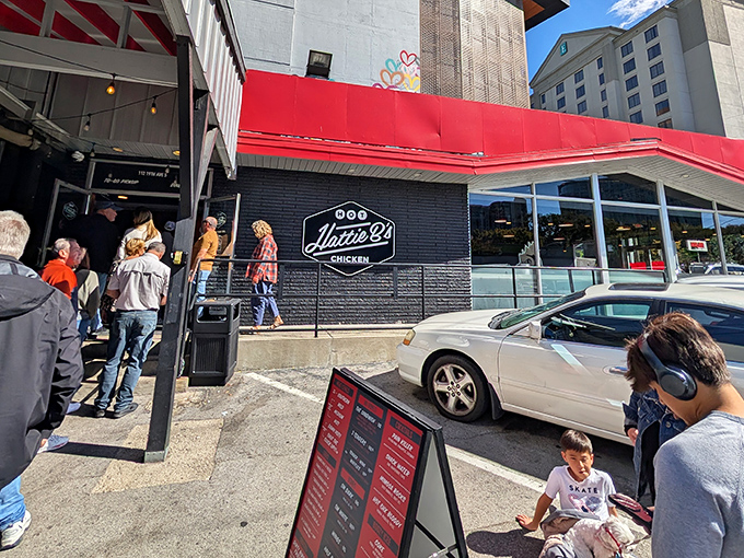 The iconic red awning of Hattie B's glows like a beacon of spicy salvation against the Nashville skyline. Hot chicken paradise awaits!