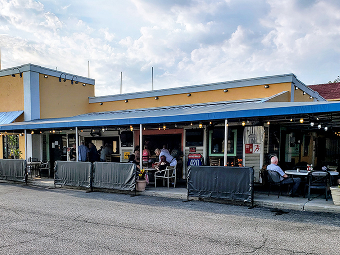 The vibrant yellow exterior of Fish On Fire welcomes seafood lovers with colorful kayaks standing guard, promising Florida flavors without the pretense.