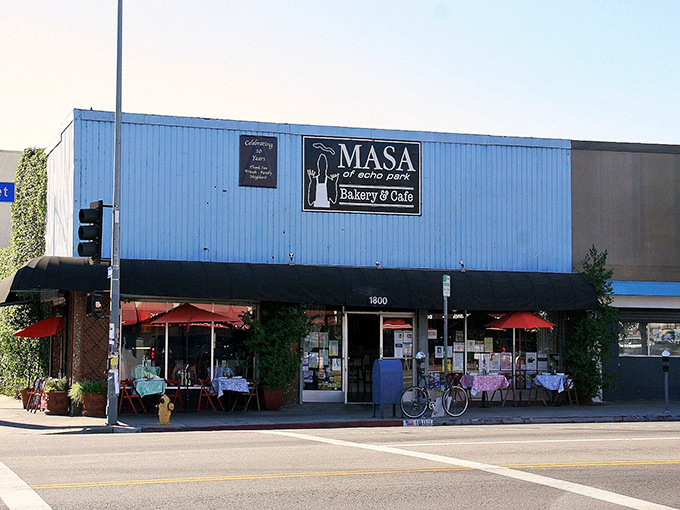 The blue exterior of Masa stands like a culinary lighthouse on Sunset Boulevard, beckoning pizza pilgrims with its no-nonsense charm and red patio umbrellas.