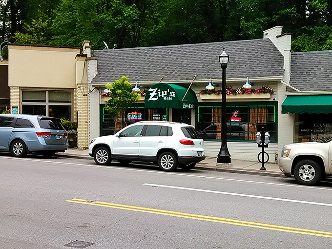 The unassuming white brick exterior of Zip's Cafe, with its signature green awning, proves that culinary greatness rarely needs flashy advertising.