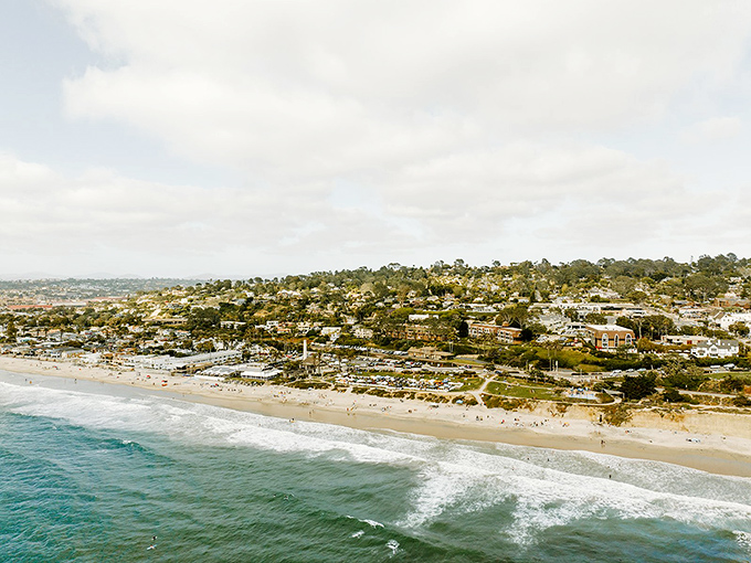 Del Mar's coastline stretches like nature's own masterpiece, where golden beaches meet residential charm. The ultimate California dream captured in one breathtaking aerial view.