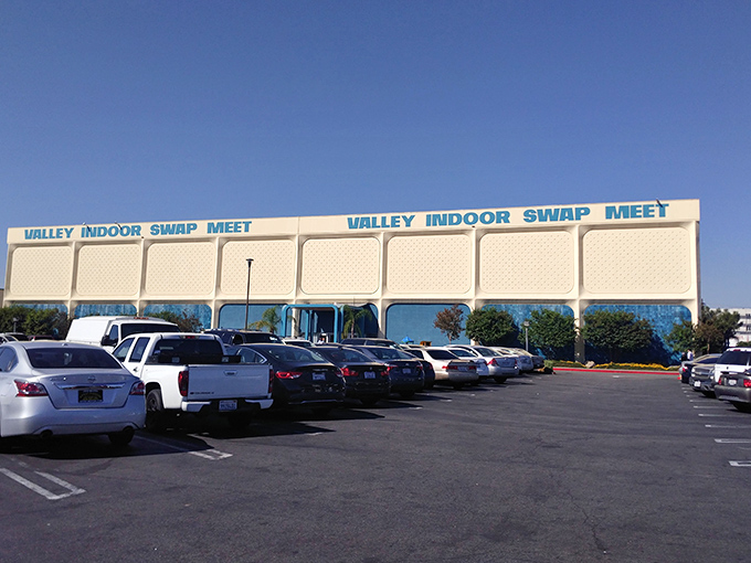 The iconic Valley Indoor Swap Meet sign stands proudly against California's endless blue sky, promising treasures within. 