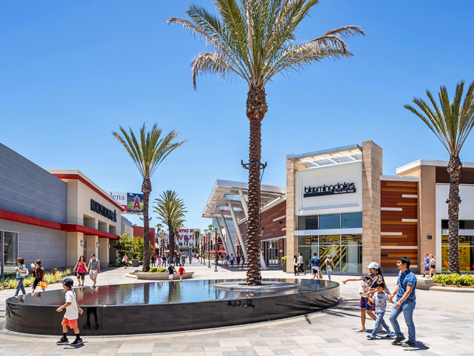 Palm trees and modern architecture create the perfect California shopping paradise under endless blue skies.