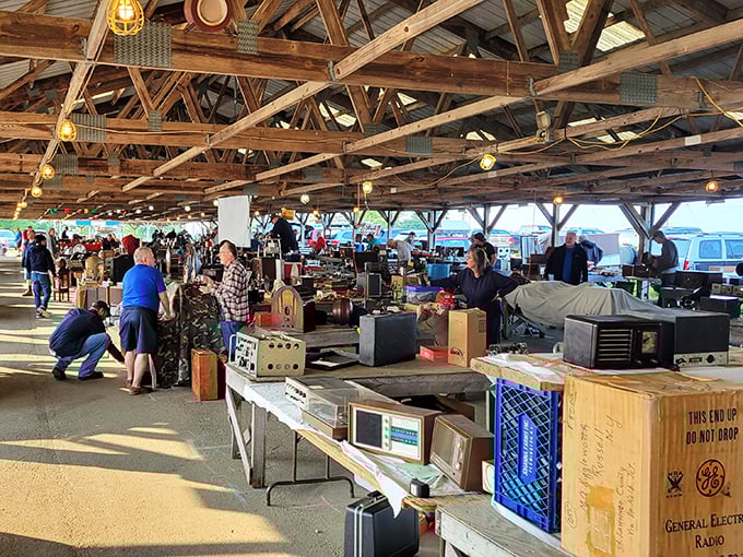 Treasure hunters navigate the cavernous barn-like structure where decades of history await discovery beneath rustic wooden beams and warm lighting.