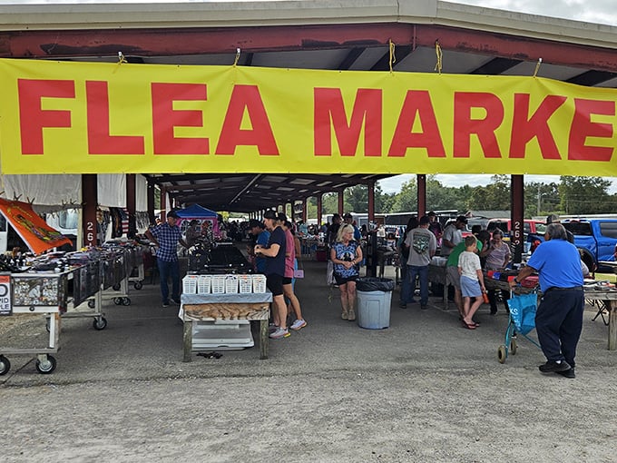 The red "FLEA MARKET" sign beckons like a siren call to bargain hunters. Treasure awaits under this bustling pavilion in Pass Christian.