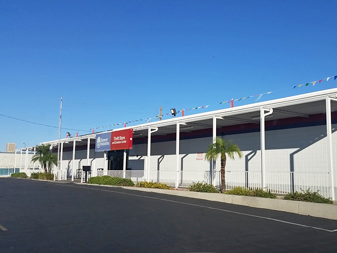 The unassuming exterior hides a bargain hunter's paradise. Those colorful pennant flags are basically saying "Treasures ahead!" in thrift-speak.