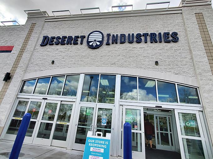 The modern facade of Deseret Industries beckons with promises of treasures within—like a department store where everything comes with a story.