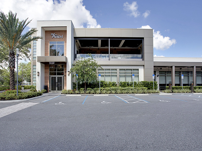 Modern elegance meets Florida charm at Del Frisco's exterior, where palm trees stand guard over what might be the best steak-eating decision of your life.