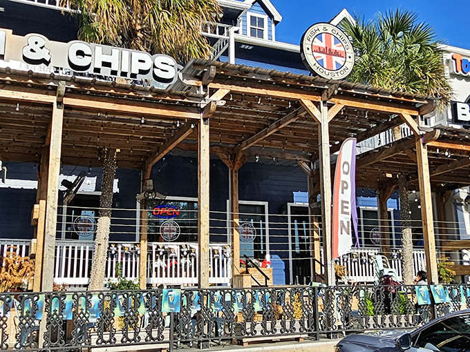 The blue facade of Fish and Chips Houston stands proudly in Kemah, where palm trees and Union Jacks create the most delightful cultural collision since tea met Texas.