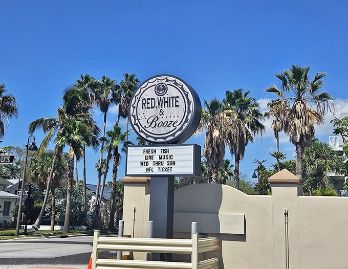 The seafoam-blue exterior of Red, White and Booze stands like a coastal sentinel, promising nautical comforts and "HAPPINESS" right above the door. Truth in advertising!
