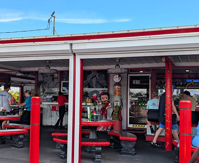 The bright yellow sign stands like a time machine on US-1, promising curb service and burger bliss since Eisenhower was signing legislation. 