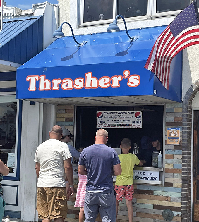 The iconic blue and orange Thrasher's sign beckons beach-goers like a potato-powered lighthouse on Rehoboth's boardwalk. Summer pilgrimage status: mandatory.