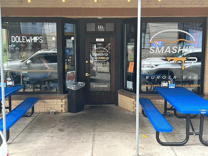 The bright blue picnic tables outside Smash'd Burger Bar are like a beacon calling to hungry travelers. No pretension here, just the promise of honest-to-goodness flavor.