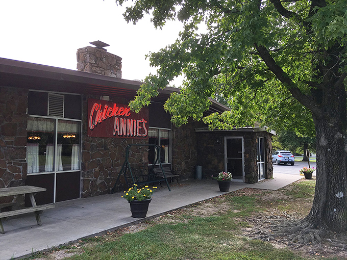The stone facade and iconic red sign of Chicken Annie's Original stands as a monument to fried chicken perfection in Pittsburg, Kansas.