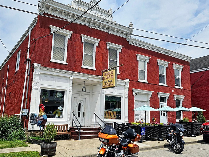 The stately red brick exterior of Wagner's Village Inn stands as a beacon of culinary tradition in Oldenburg, complete with a welcoming rooster sentinel.