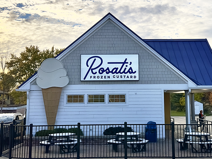 Rosati's glows like a frozen dessert lighthouse at dusk, its neon ice cream cone beckoning weary travelers toward sweet salvation.