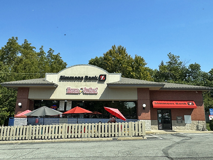 The unassuming brick storefront houses frozen custard magic. Those red umbrellas aren't just for show&mdash;they're beacons calling dessert enthusiasts to paradise.