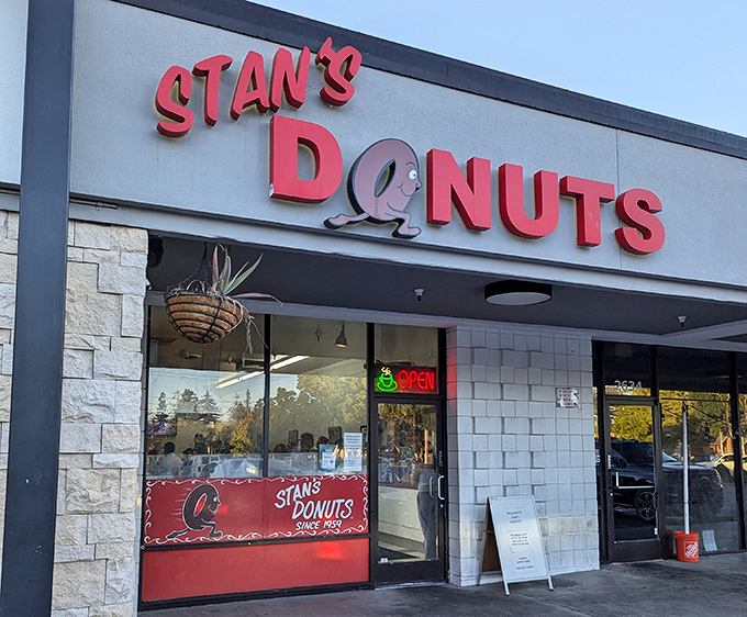 The iconic red sign of Stan's Donuts beckons like a lighthouse for the sweet-toothed sailors of Santa Clara.