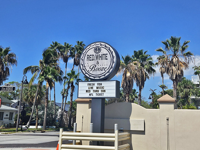 The seafoam-blue exterior of Red, White and Booze stands like a coastal sentinel, promising nautical comforts and "HAPPINESS" right above the door. Truth in advertising!