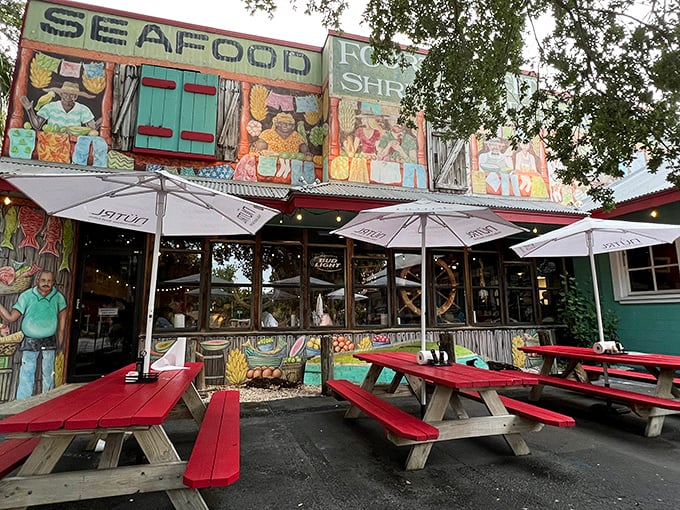 The colorful exterior of Fourth Street Shrimp Store beckons like a siren song, with vibrant murals and red picnic tables promising seafood paradise ahead.
