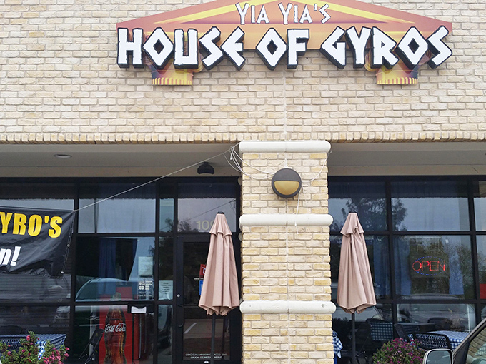 The glowing sign of Yia Yia's House of Gyros beckons like a Mediterranean lighthouse in a sea of Texas strip malls. Greek paradise awaits inside!