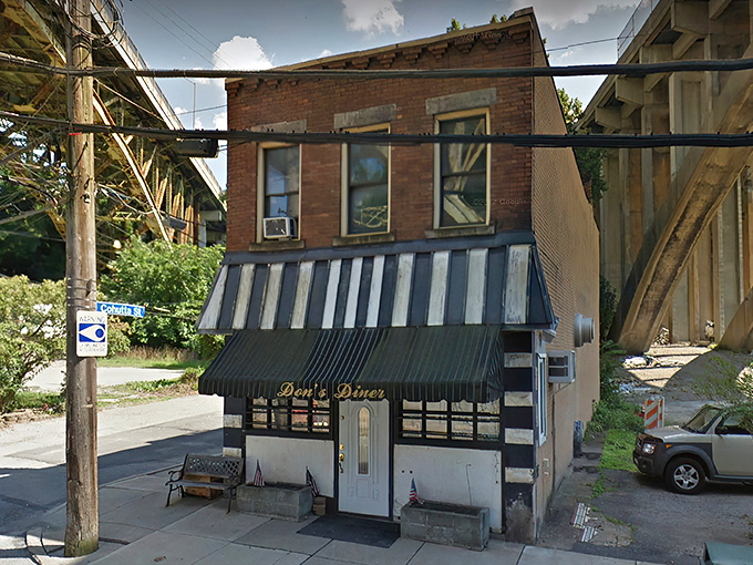 Don's Diner stands proudly beneath Pittsburgh's infrastructure, its classic striped awning and flower boxes offering a warm welcome to hungry travelers.