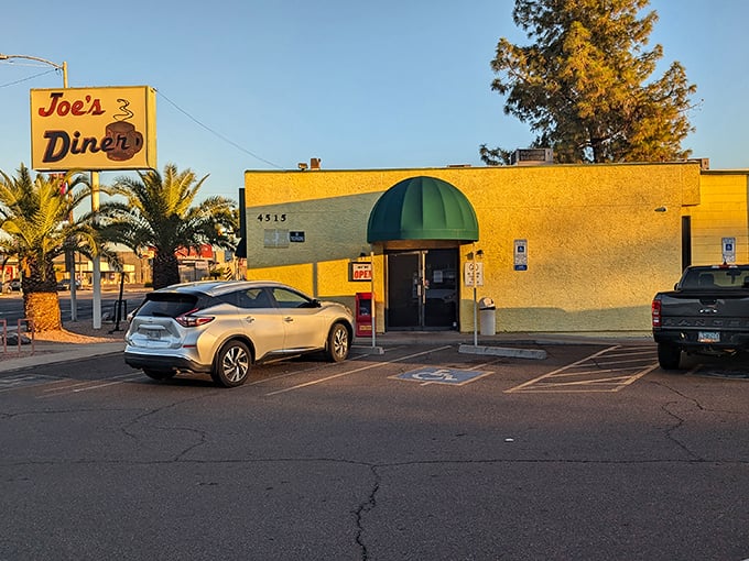 The unassuming yellow exterior of Joe's Diner stands like a beacon of breakfast hope in Phoenix, promising hash brown nirvana behind that green awning.