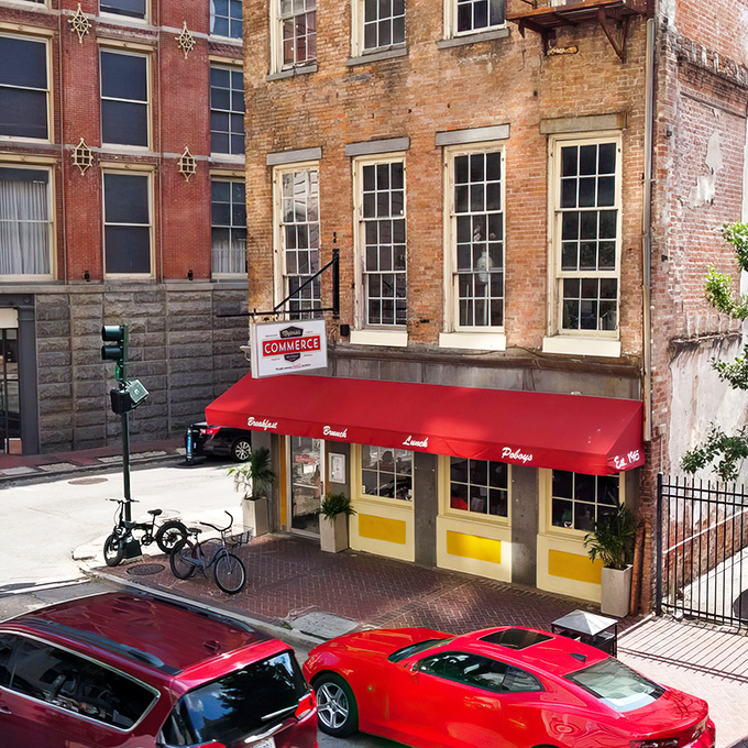 The iconic red awning of Majoria's Commerce Restaurant stands out against historic brick, a beacon for breakfast pilgrims in New Orleans' CBD.