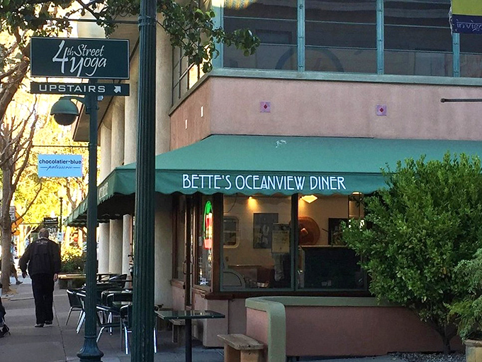 The mint-green awning of Oceanview Diner beckons like a time portal to simpler days when breakfast solved everything and calories didn't count.