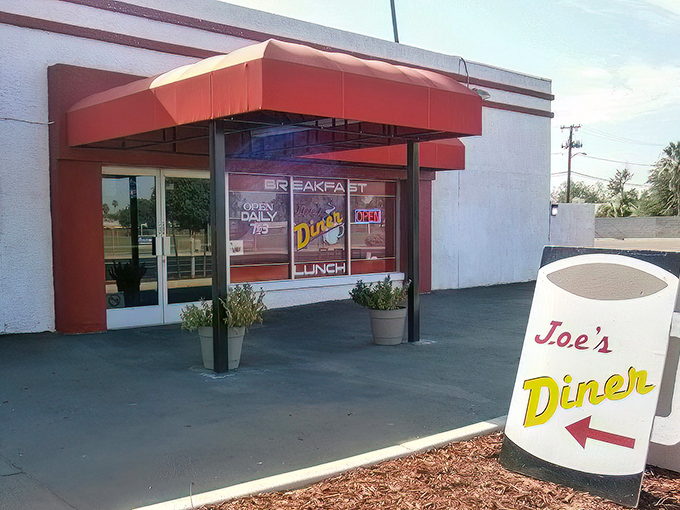 The unassuming exterior of Joe's Diner stands like a beacon of breakfast hope in Phoenix, promising hash brown nirvana behind that green awning.